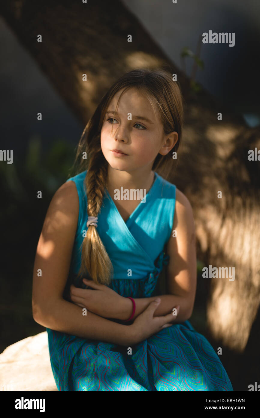 Cute girl sitting on the tree Stock Photo - Alamy
