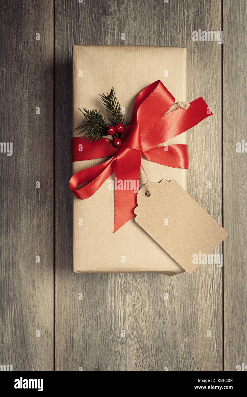 Wrapped Christmas gift tied with red ribbon Stock Photo - Alamy