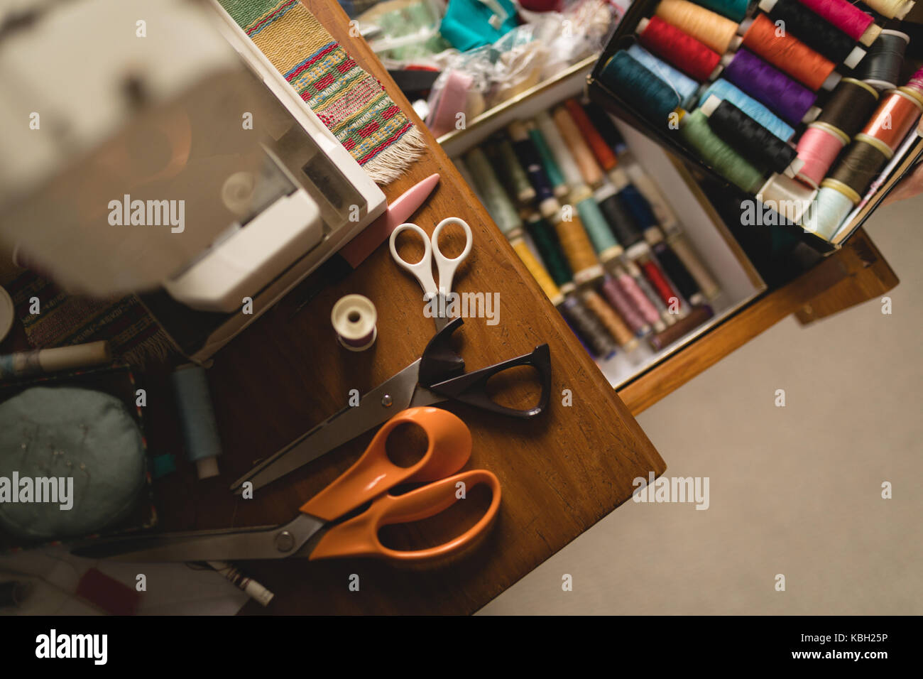 Sewing machine, scissors and threads on table at home Stock Photo - Alamy