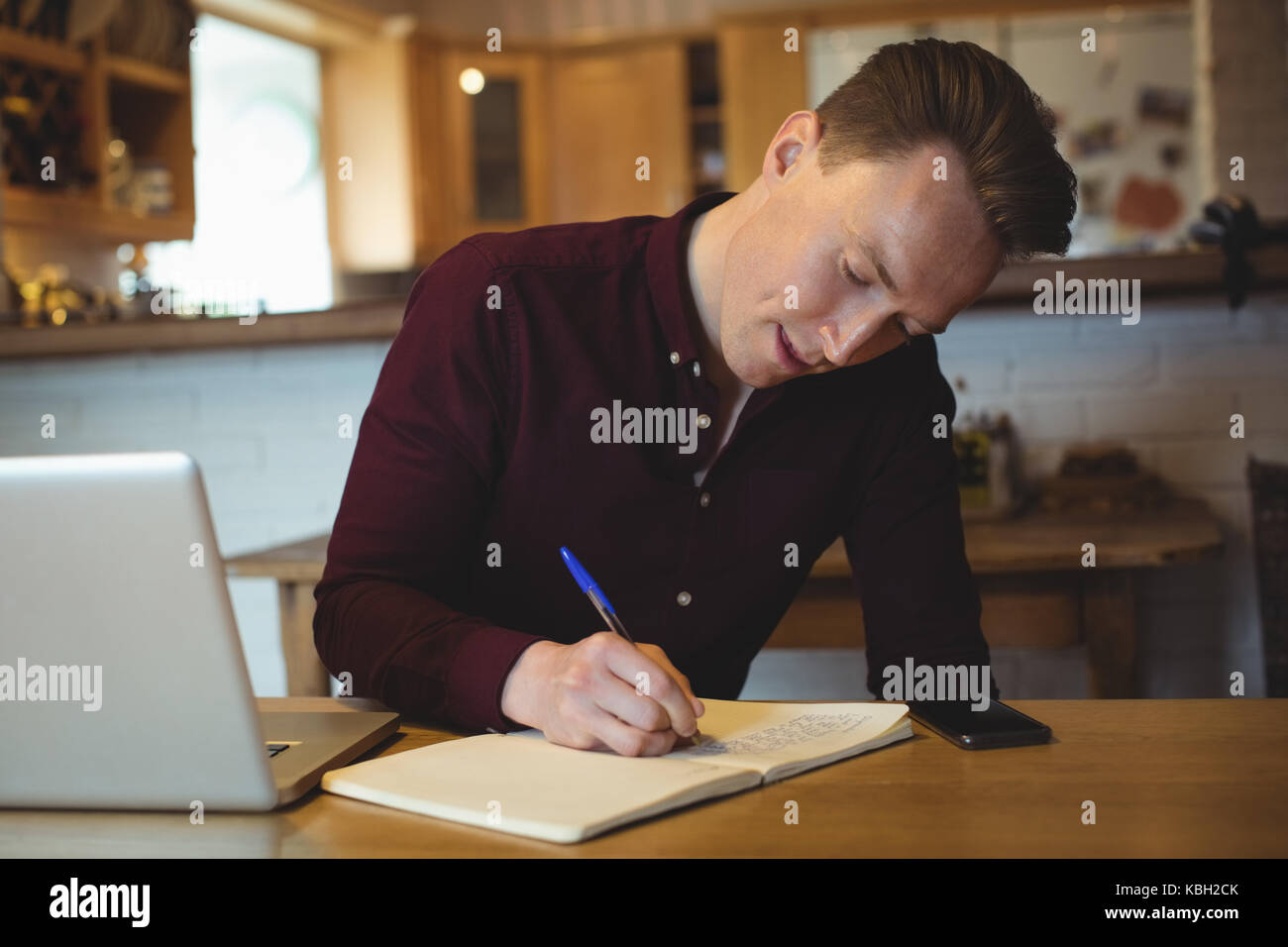 Handsome man writing in diary at home Stock Photo - Alamy