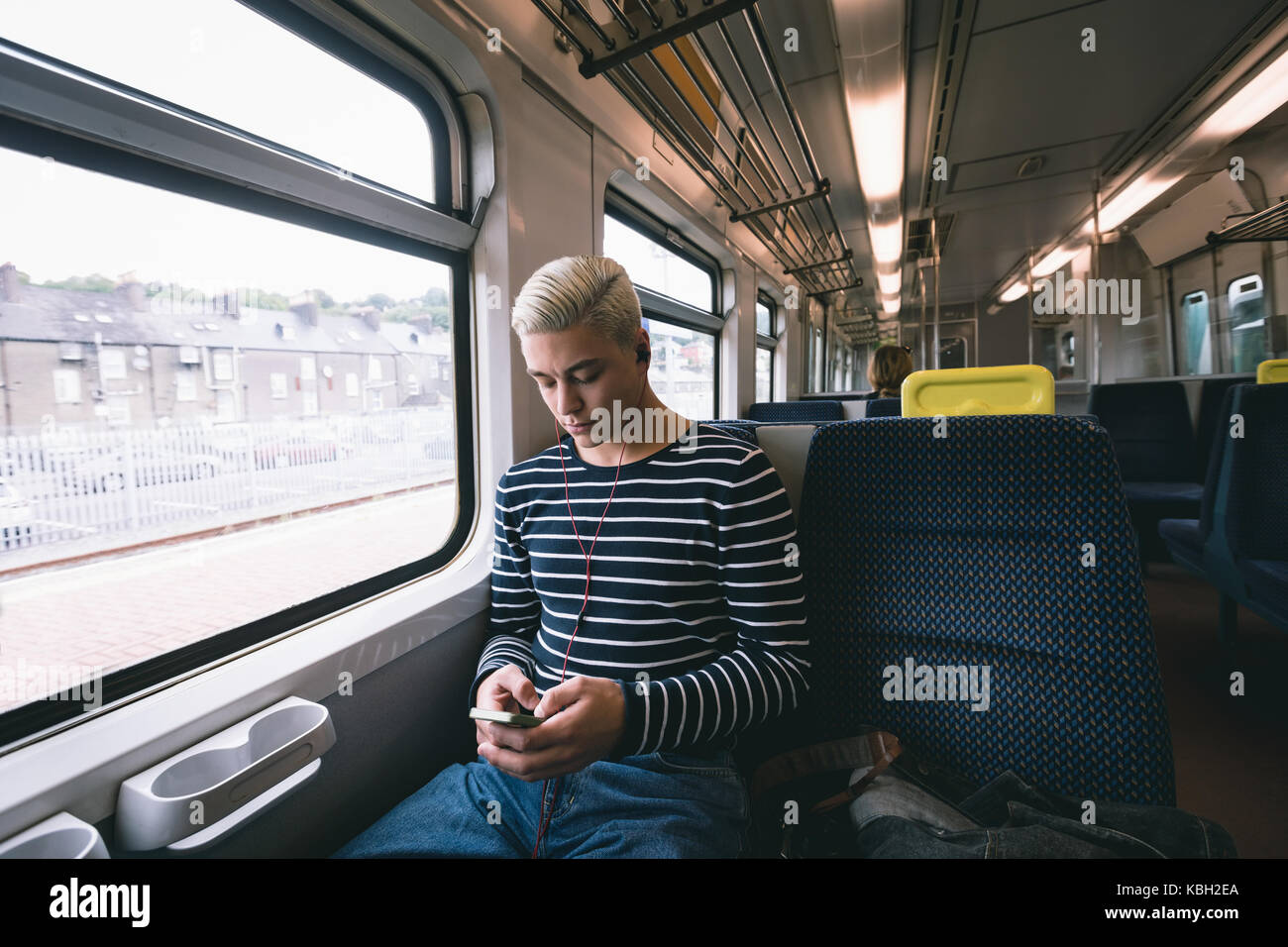 Handsome man using mobile phone while traveling in metro Stock Photo ...