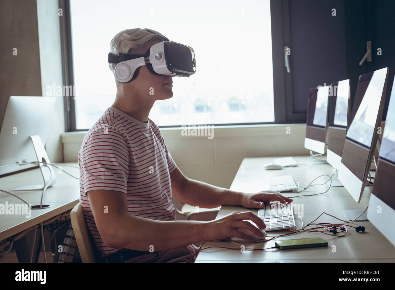 Man using virtual reality while working on personal computer in office ...