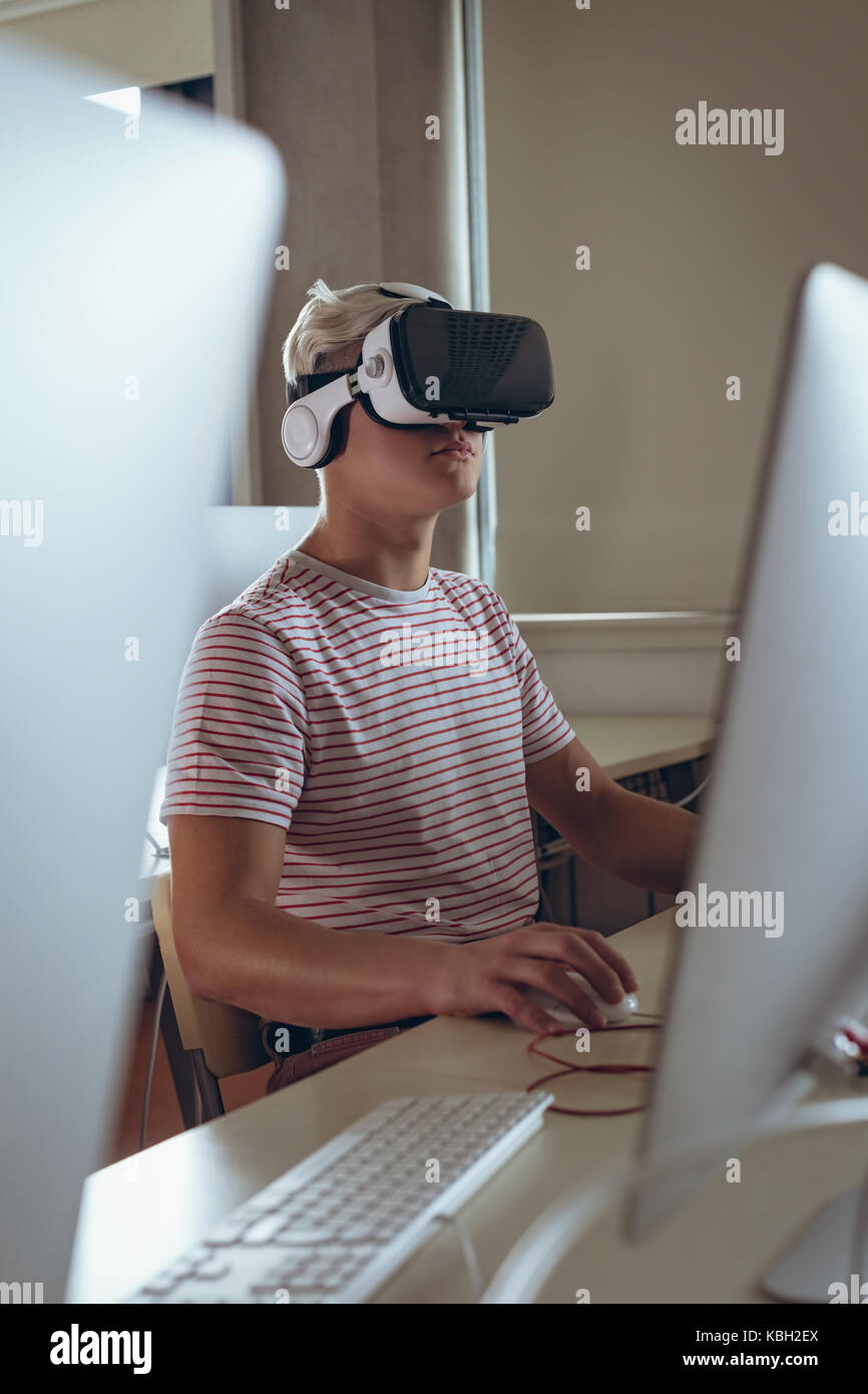 Man using virtual reality while working on personal computer in office ...