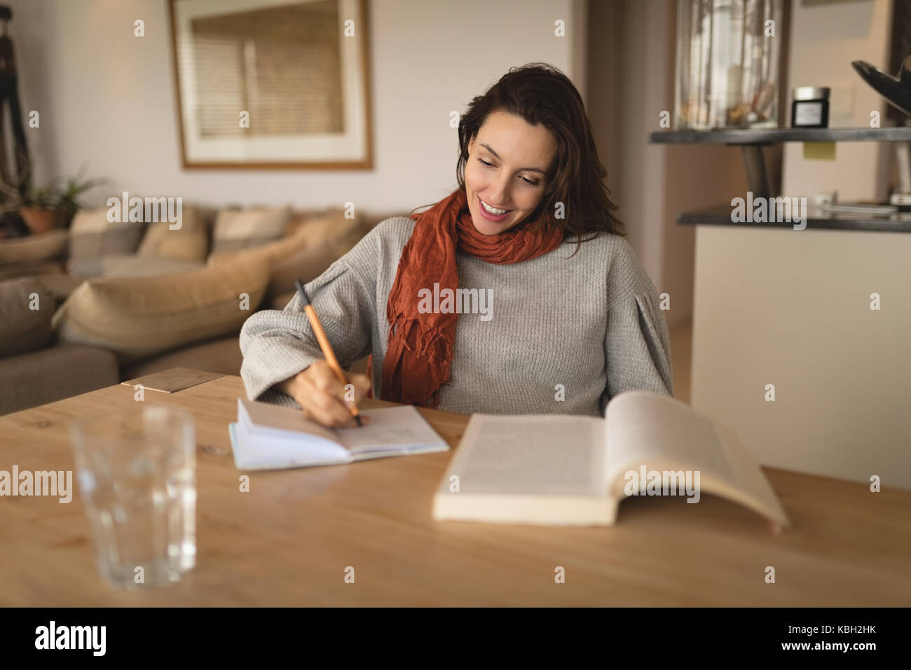 Pregnant woman writing in a book while sitting Stock Photo - Alamy