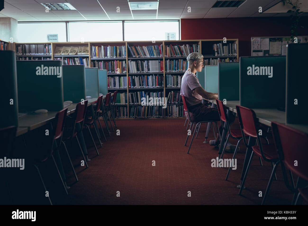 Man studying at desk in library Stock Photo - Alamy