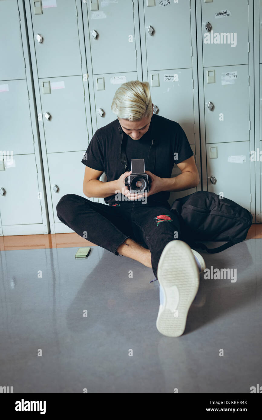 University male student using camera in the corridor of college Stock ...