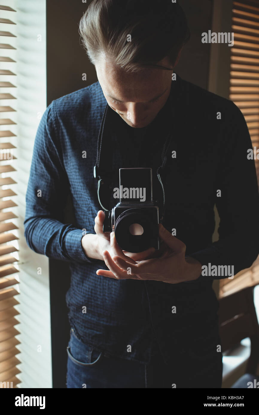 Man holding vintage camera near window at home Stock Photo - Alamy