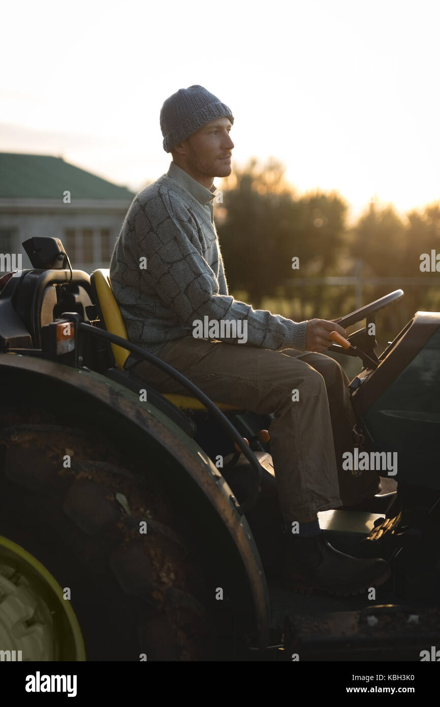 Farmer sitting on tractor on a sunny day Stock Photo - Alamy