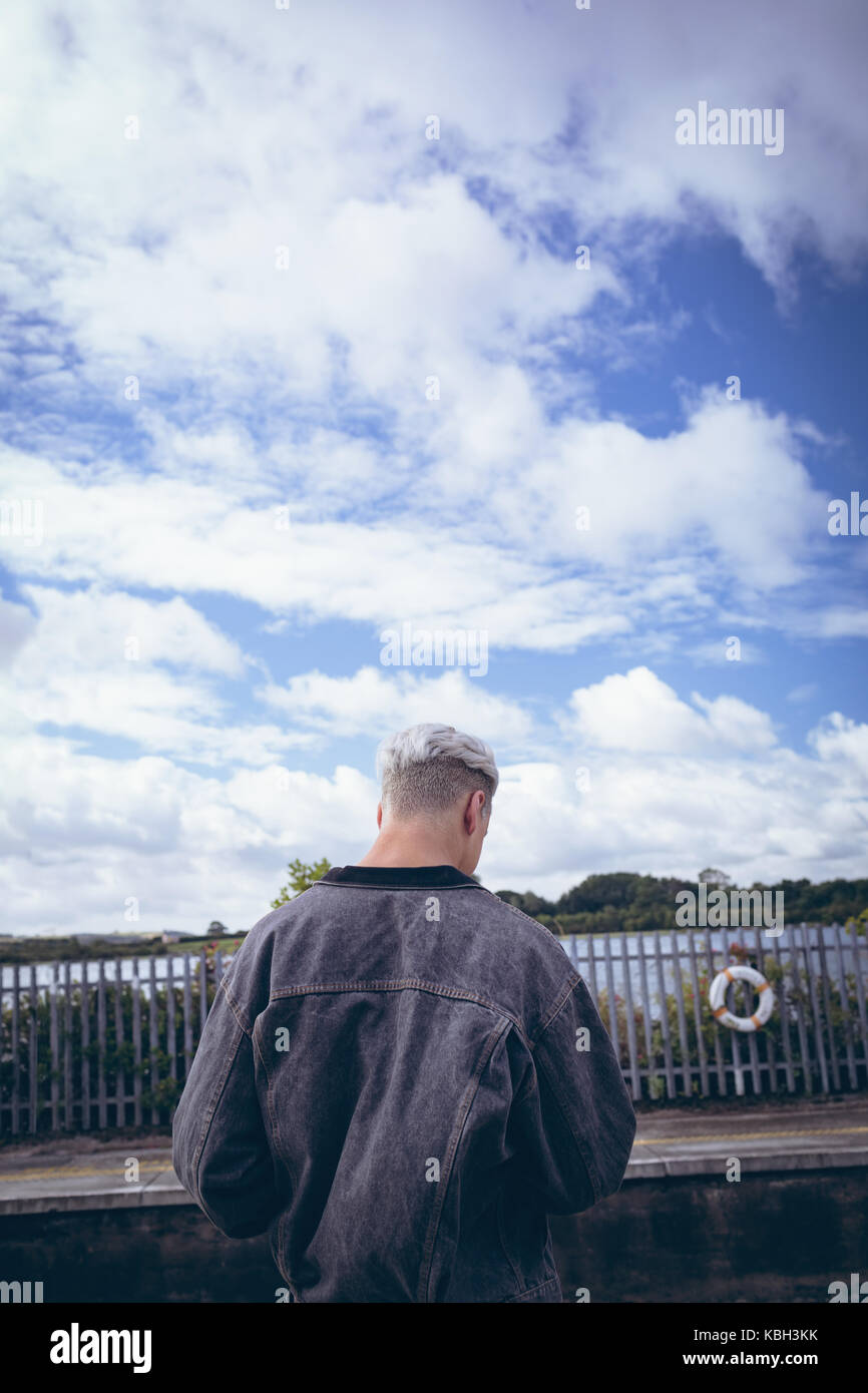 Rear view of man standing on platform at railway station Stock Photo ...