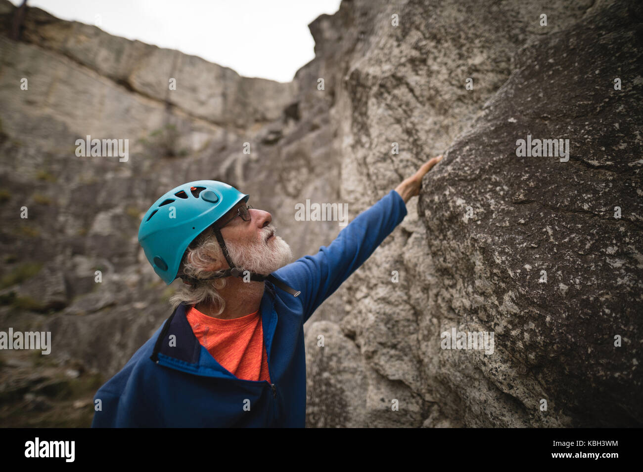 Man climbing a cliff in countryside Stock Photo - Alamy
