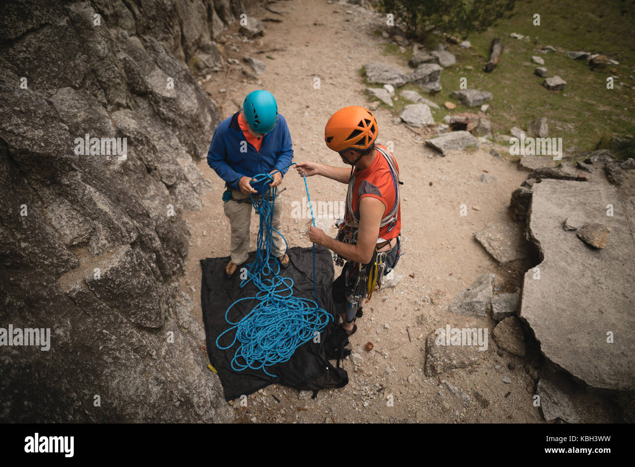Hikers arranging climbing rope near cliff Stock Photo - Alamy