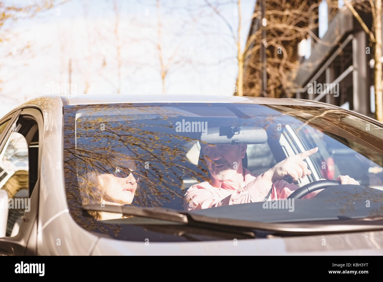 Couple interacting with each other while driving car on a sunny day ...