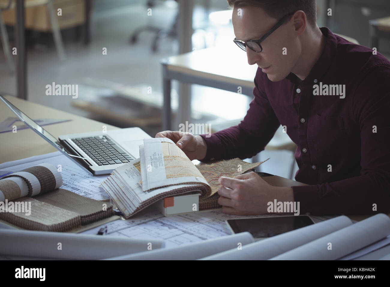 Architect looking at sample in studio Stock Photo - Alamy