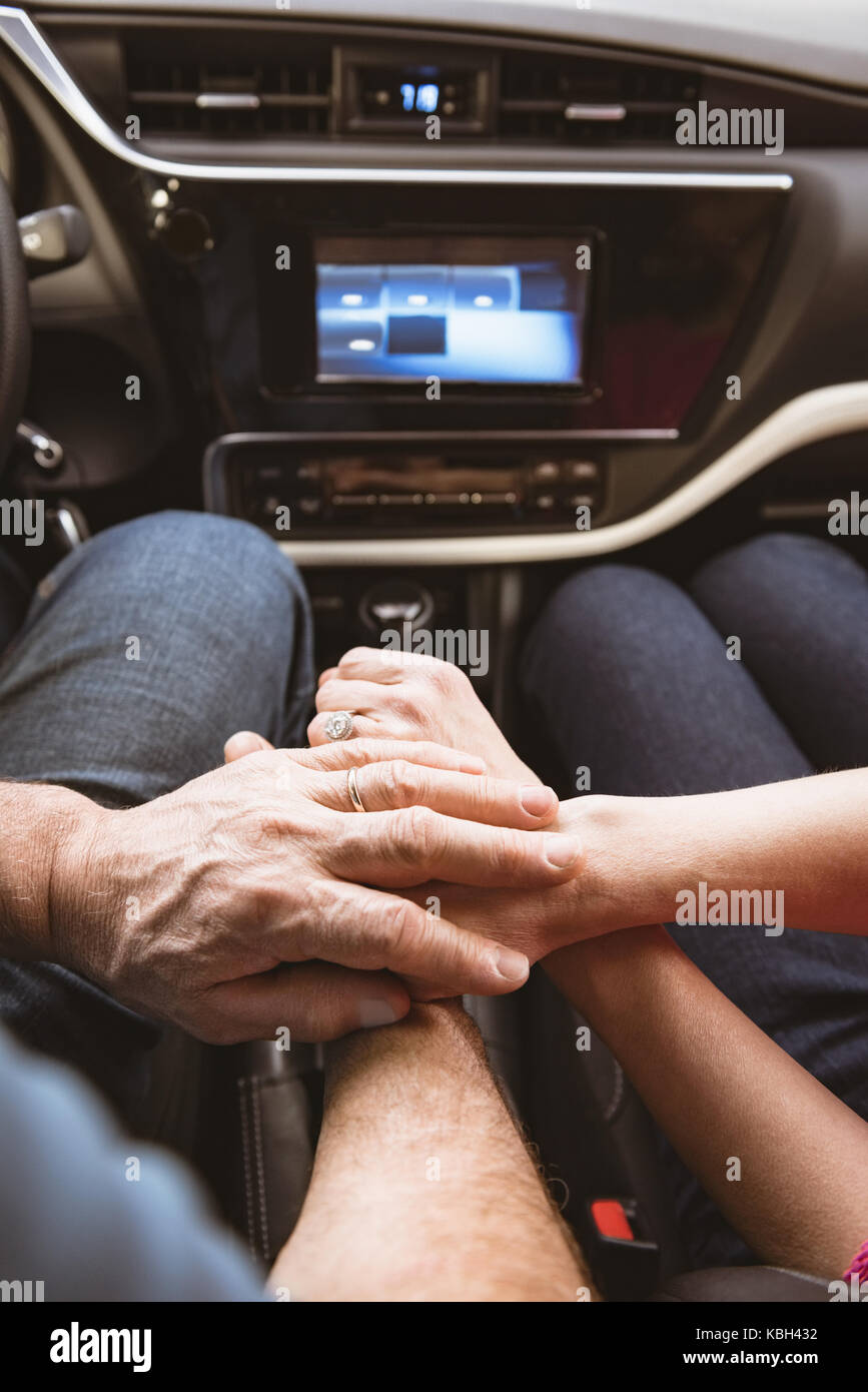 Close-up of couple holding hands in car Stock Photo - Alamy
