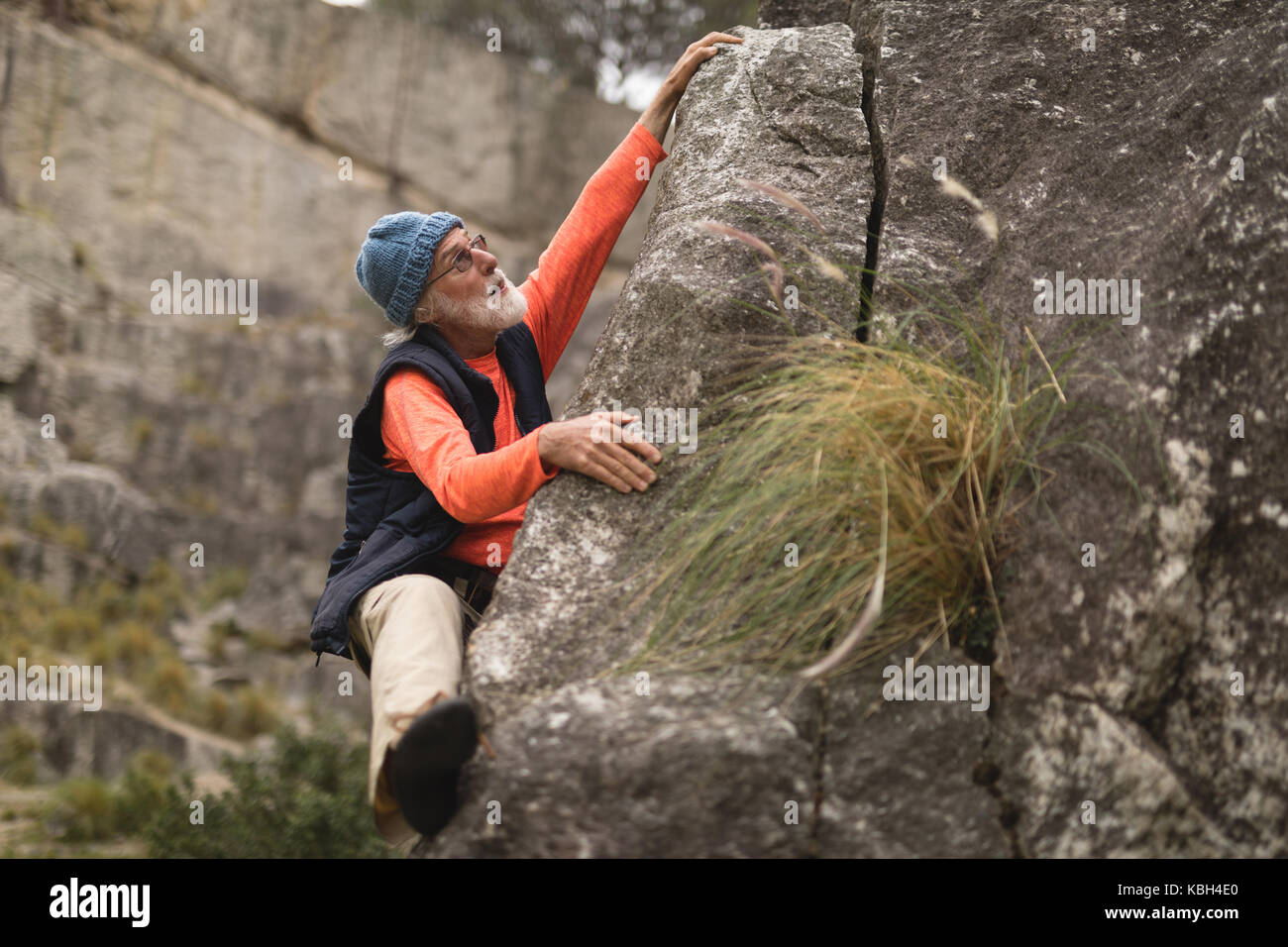 Determined senior man climbing mountain Stock Photo - Alamy