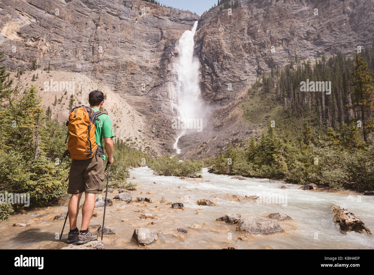 Man standing near waterfall in countryside Stock Photo - Alamy