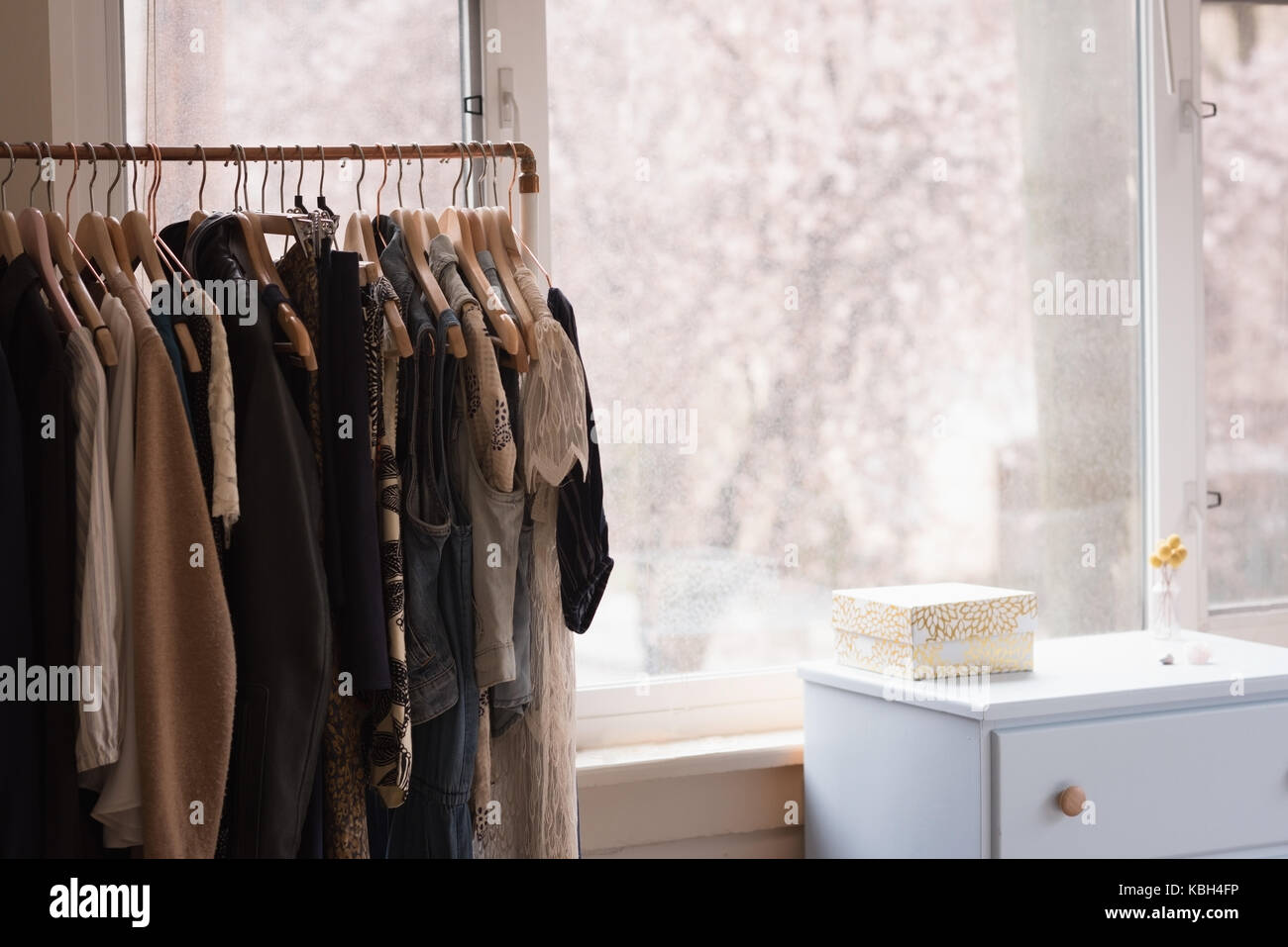 Clothes rack by glass window at home Stock Photo - Alamy