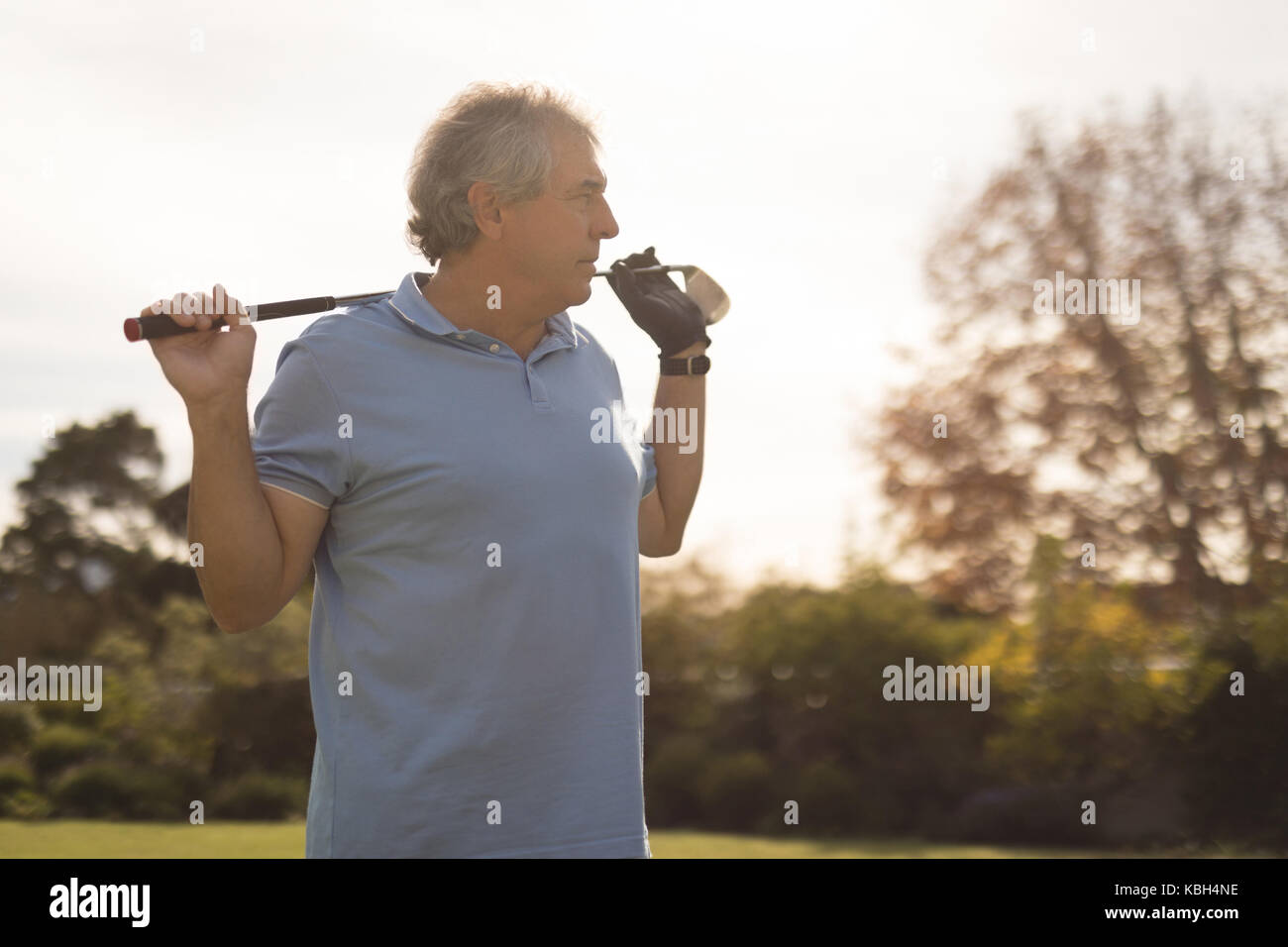 Senior man holding golf stick in golf course Stock Photo - Alamy