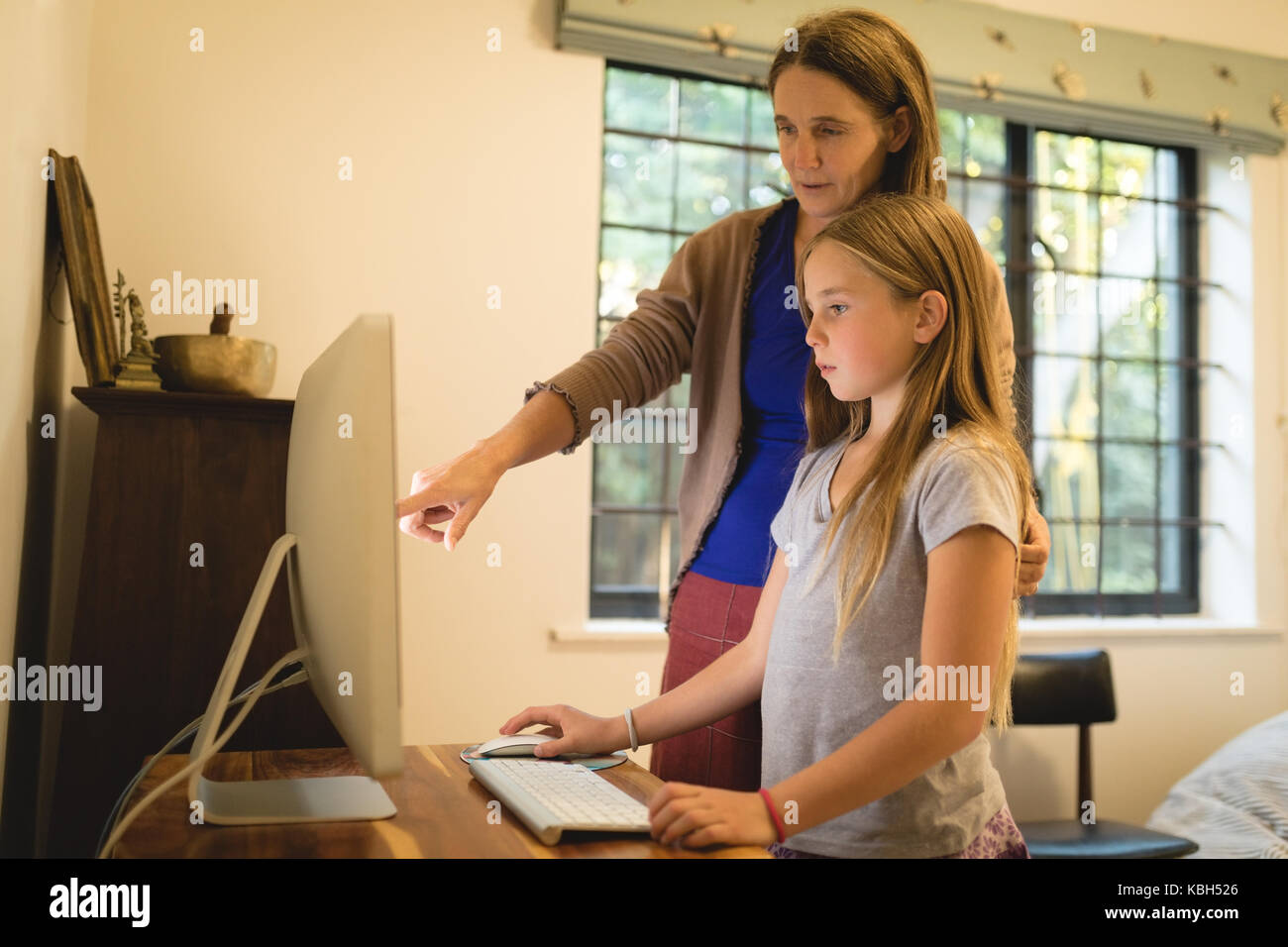 Girl using desktop pc at home Stock Photo - Alamy