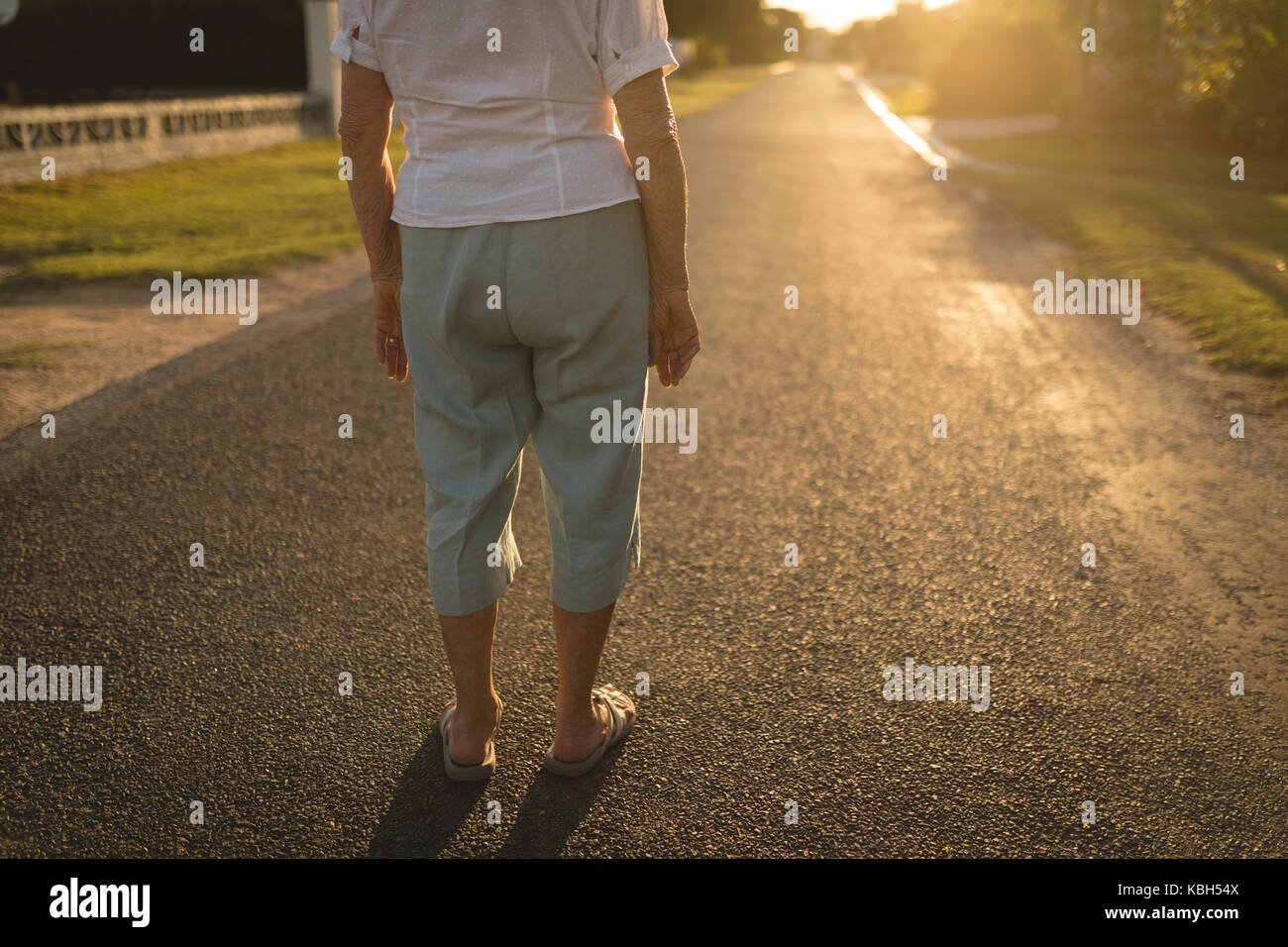 Rear view of senior woman standing on the road Stock Photo - Alamy