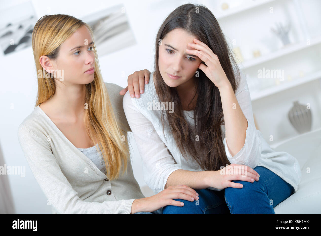 woman comforting crying friend at sofa in home Stock Photo - Alamy