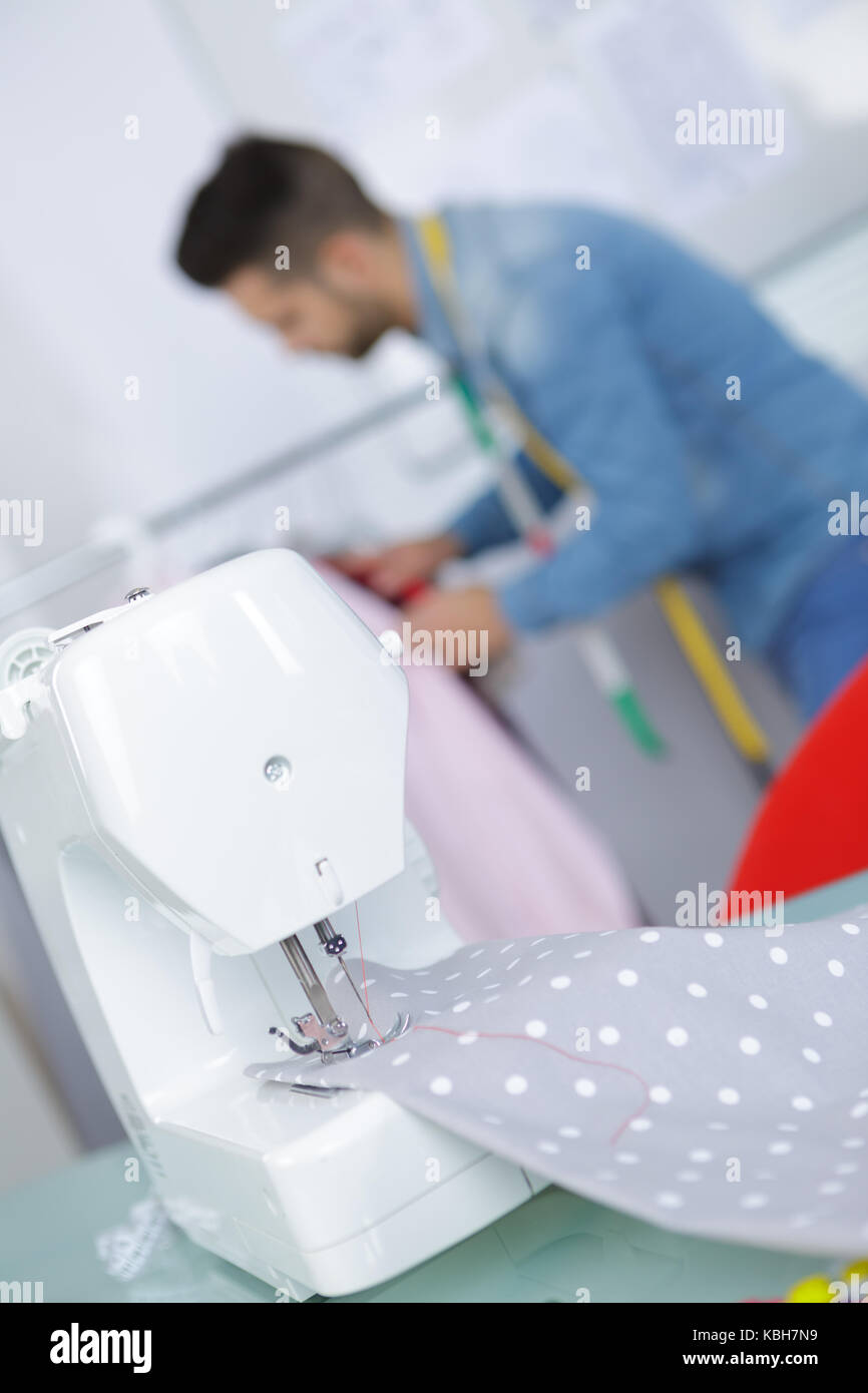 handsome fashion designer sewing with a sewing machine Stock Photo - Alamy