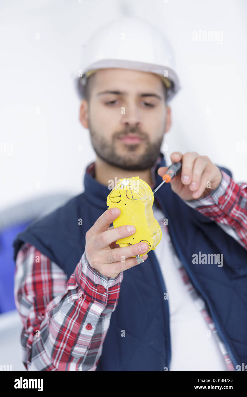 electrician with screwdriver fixing socket Stock Photo - Alamy