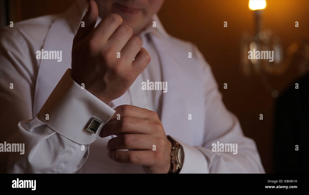 Groom is holding hands on the tie, wedding suit. close up of a hand man ...