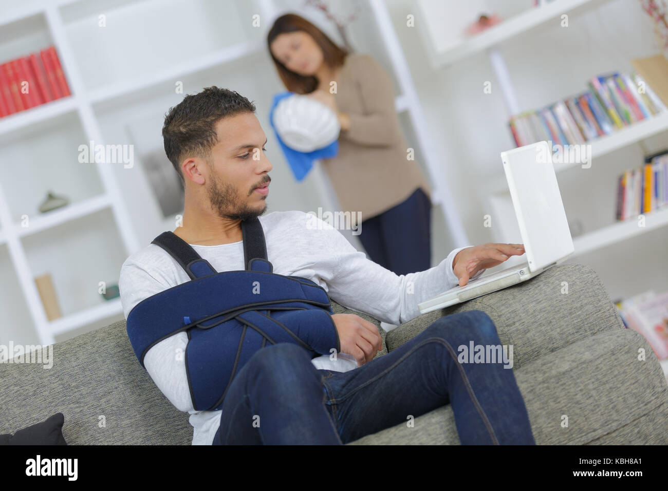 man with arm sling support using laptop Stock Photo - Alamy