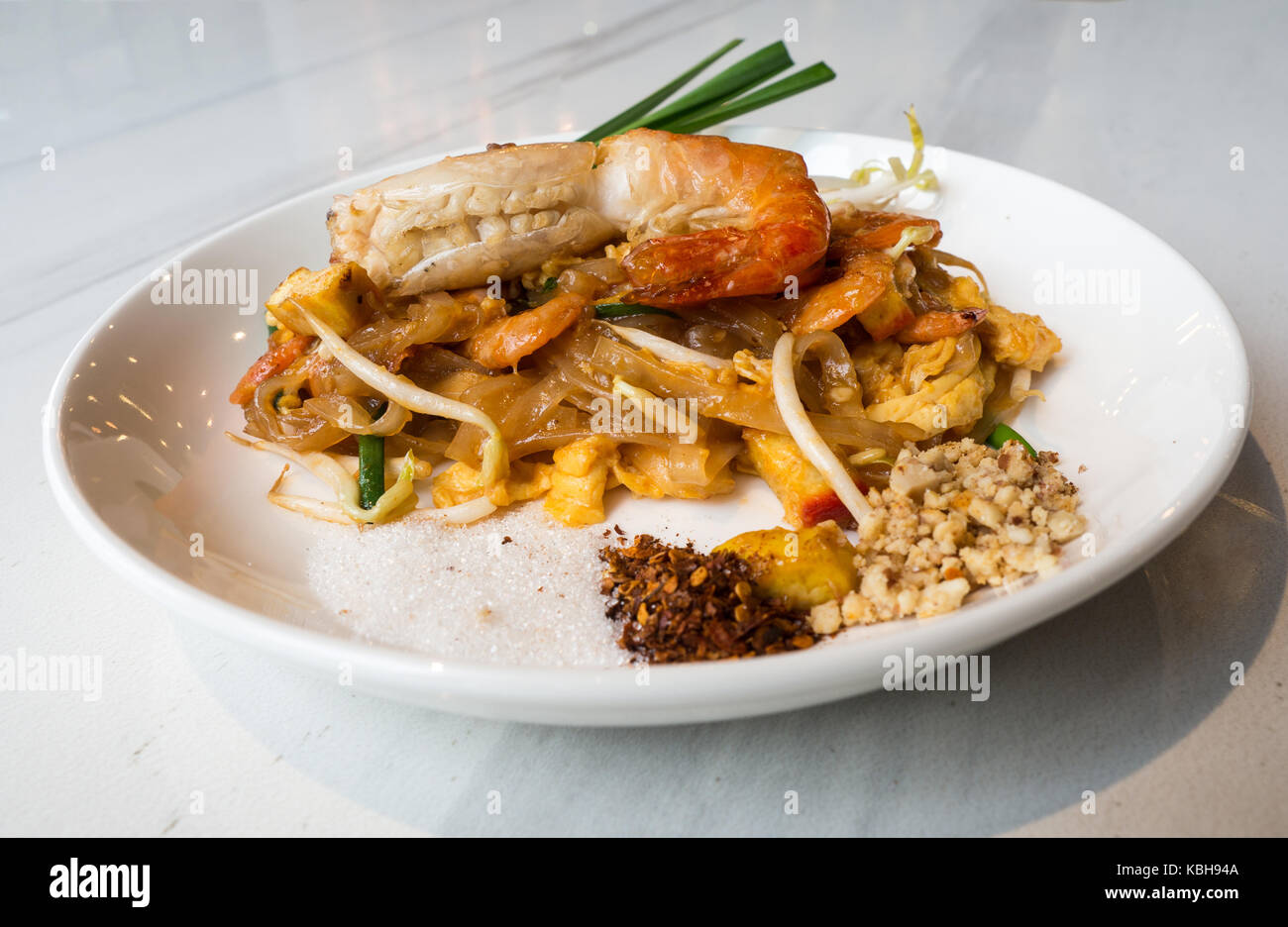 Fried Rice Sticks with Shrimp (PAD THAI GOONG SOD) put a white plate ...
