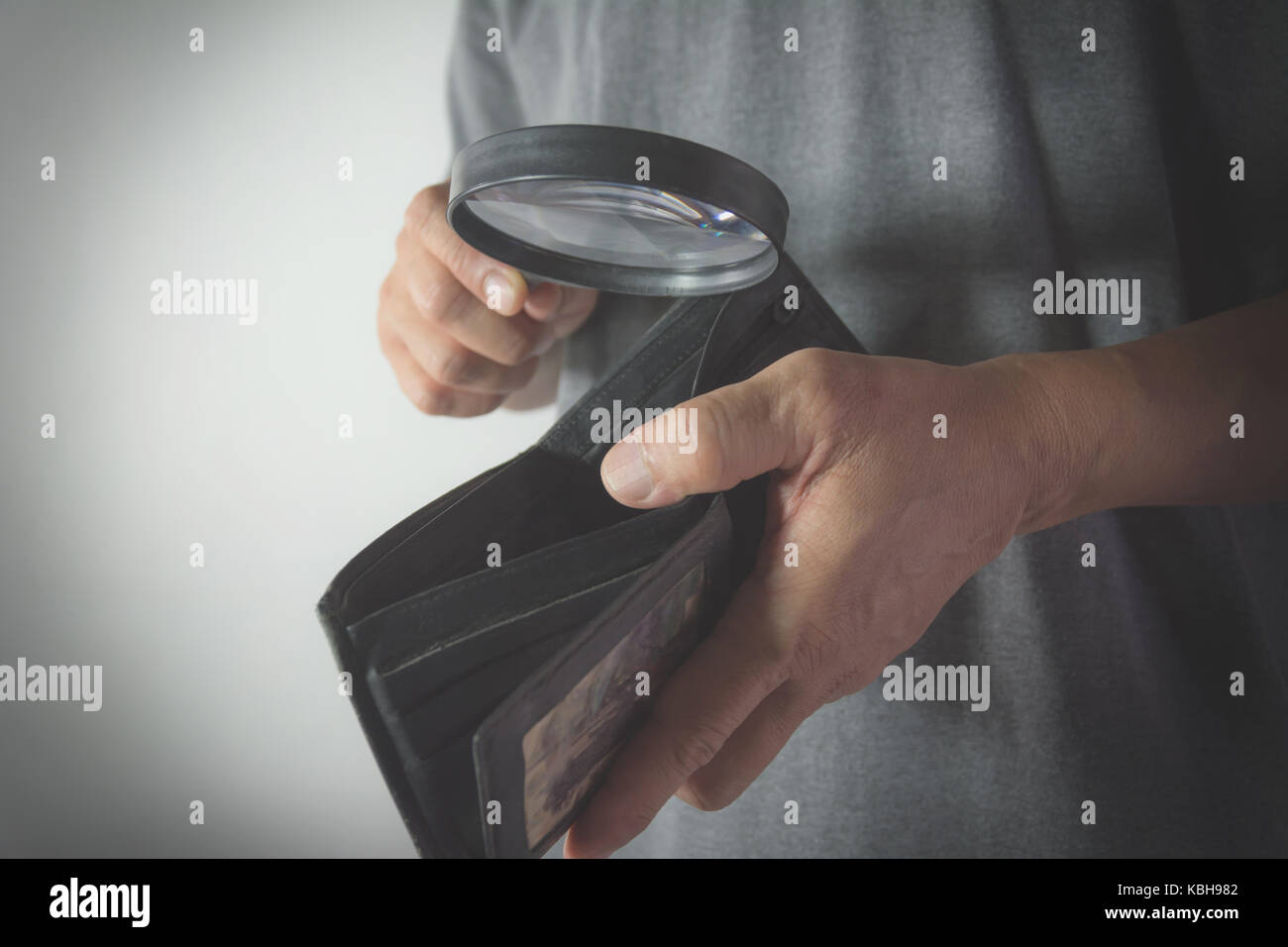 Close-up man standing and holding magnifying glass for looking in the ...