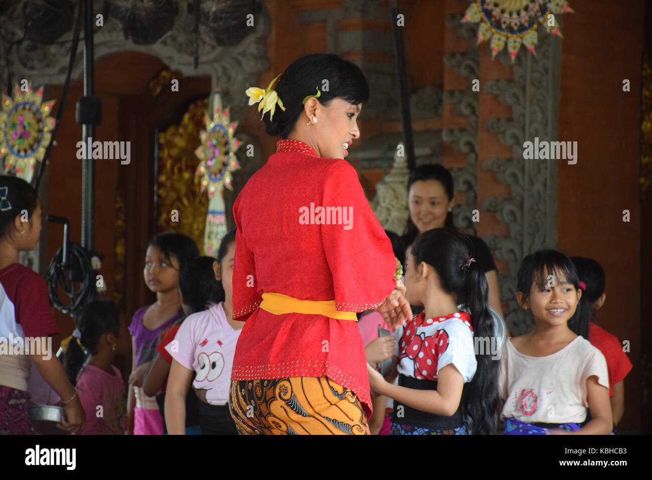 Beautiful indonesian woman teaching balinese dance to young kids in ...