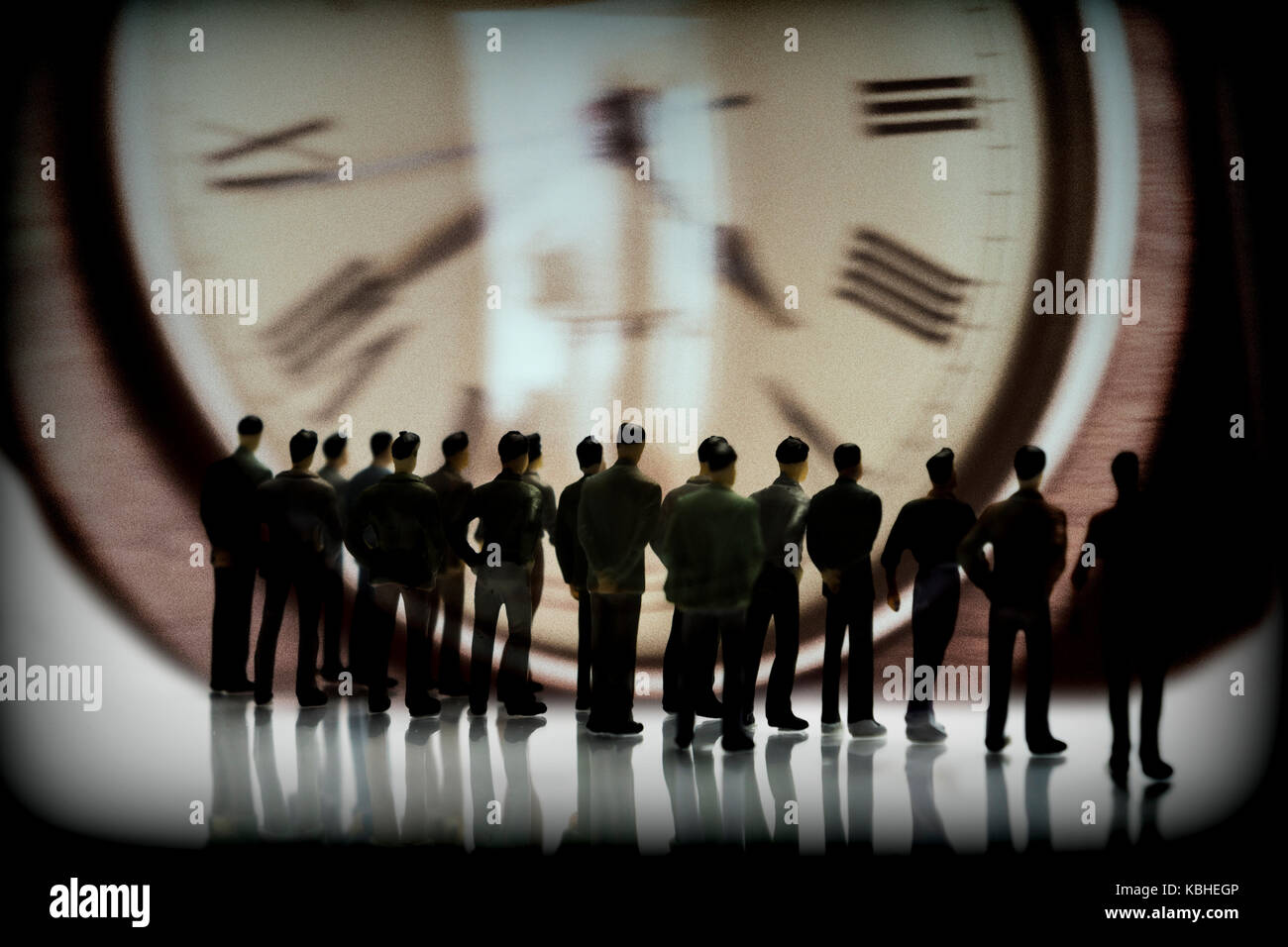 men's silhouettes opposite to a clock, conceptual image Stock Photo - Alamy