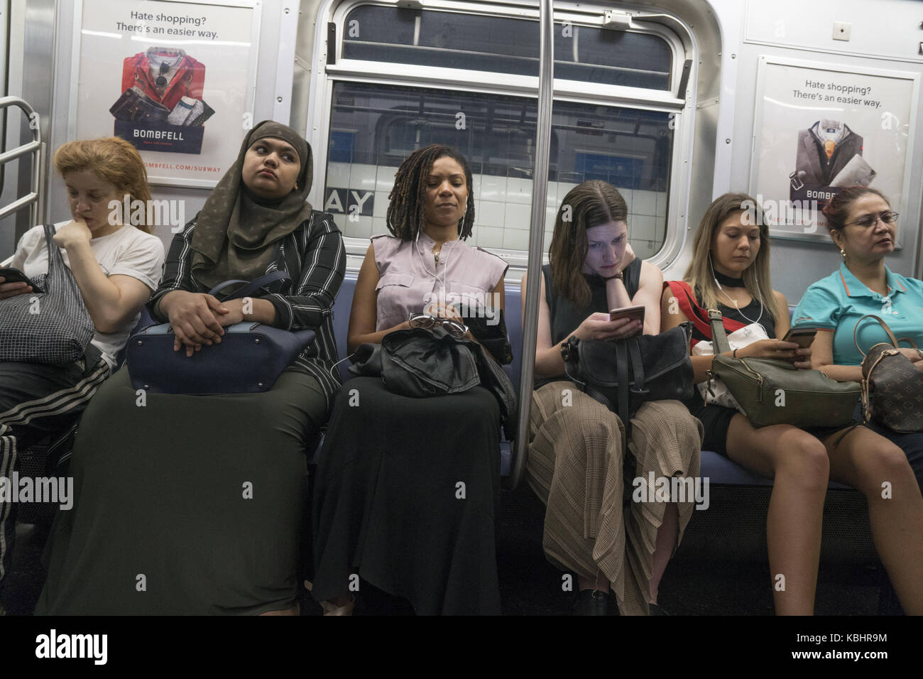 Five women sitting riding a New York City subway train in Brooklyn, NY ...