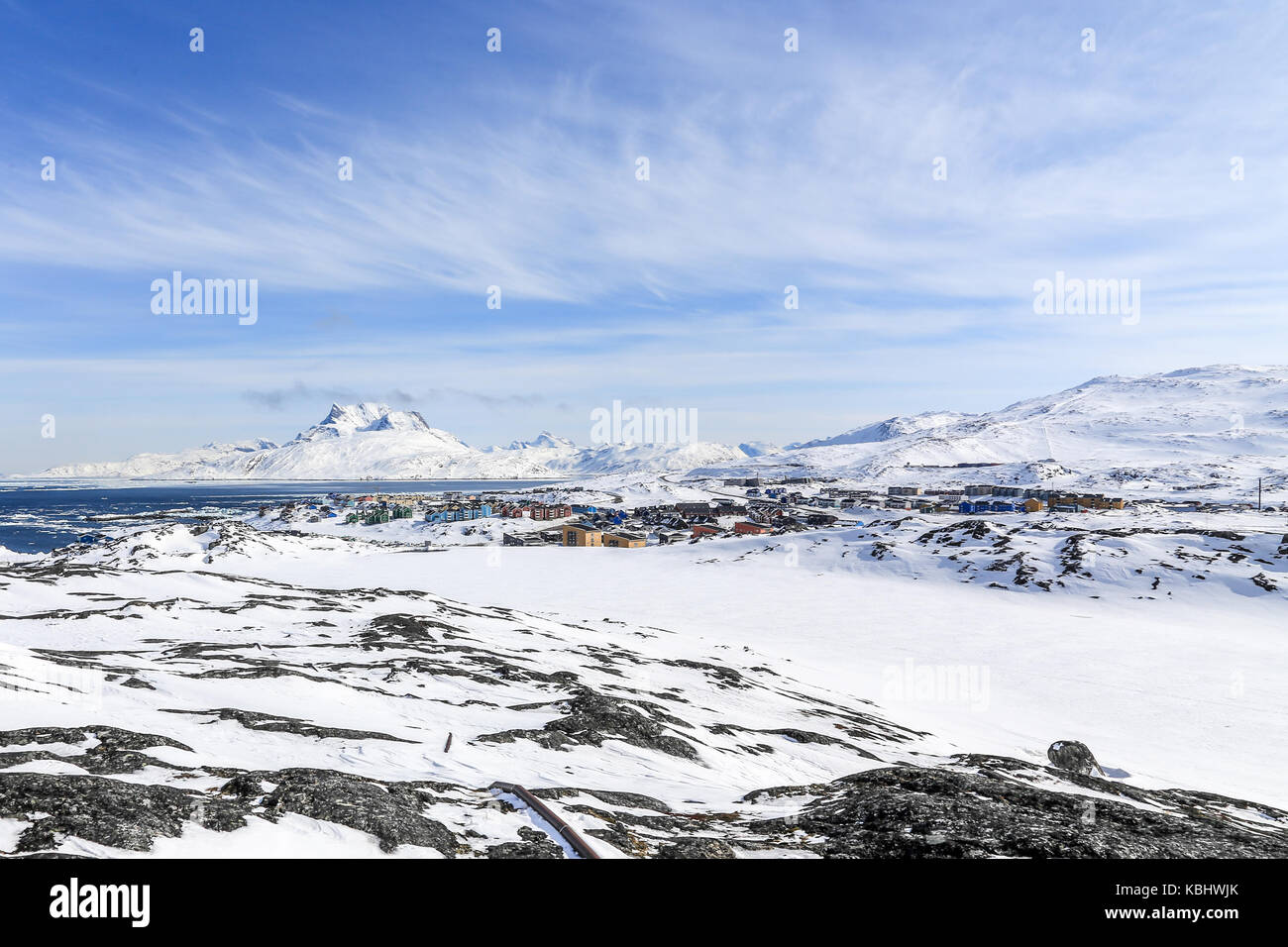 Nuuk city suburb at the fjord, snow landscape with blue sky and ...