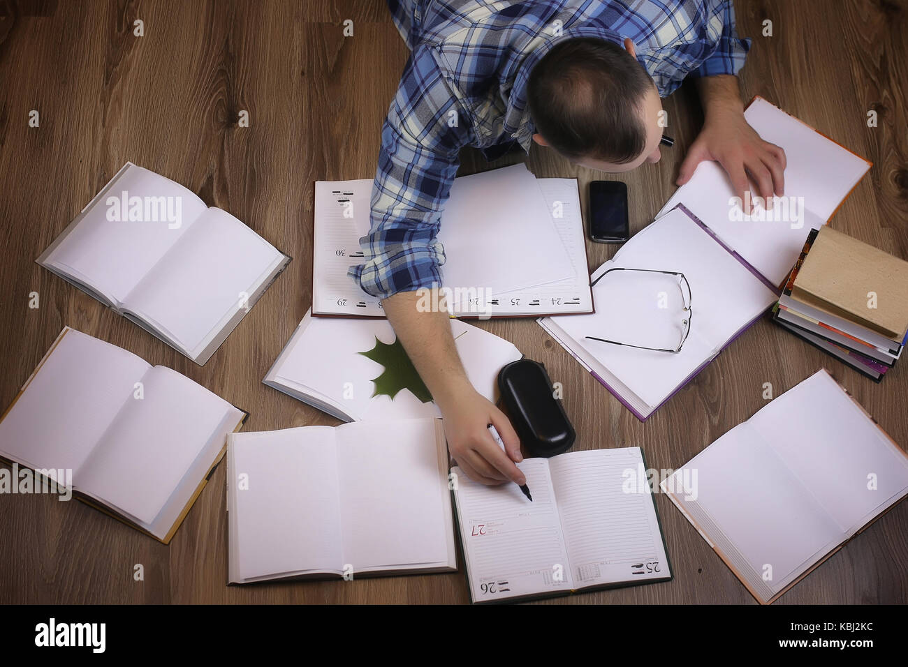 man working with book on the floor Stock Photo - Alamy