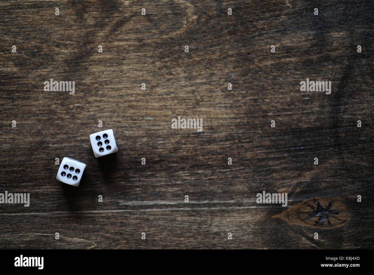 White dices on a brown wooden texture table Stock Photo - Alamy
