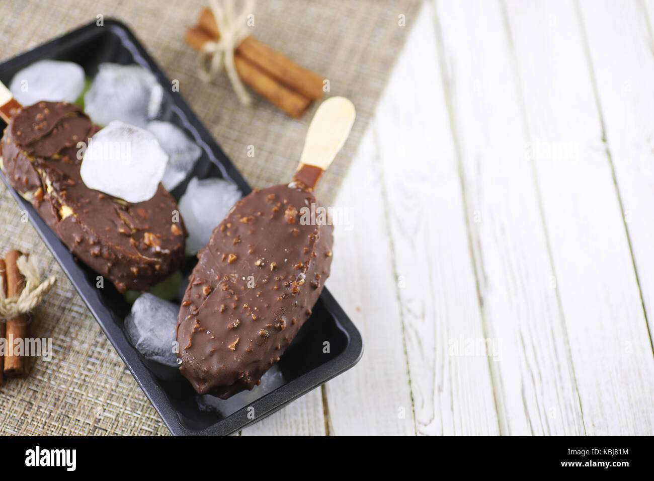 Dessert chocolate ice cream with nuts on wooden stick Stock Photo - Alamy