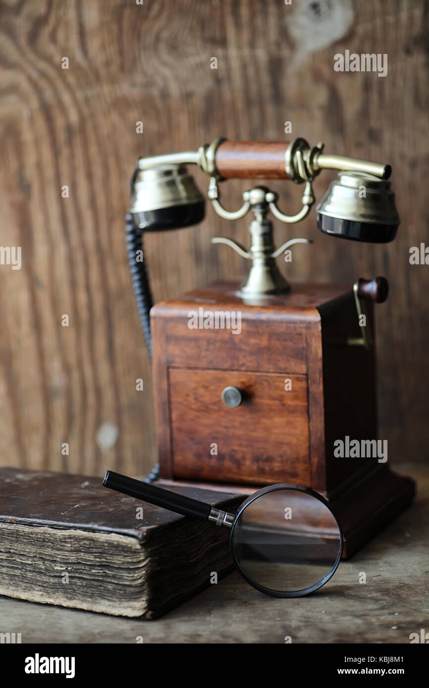Old telephone and retro book on a wood Stock Photo - Alamy