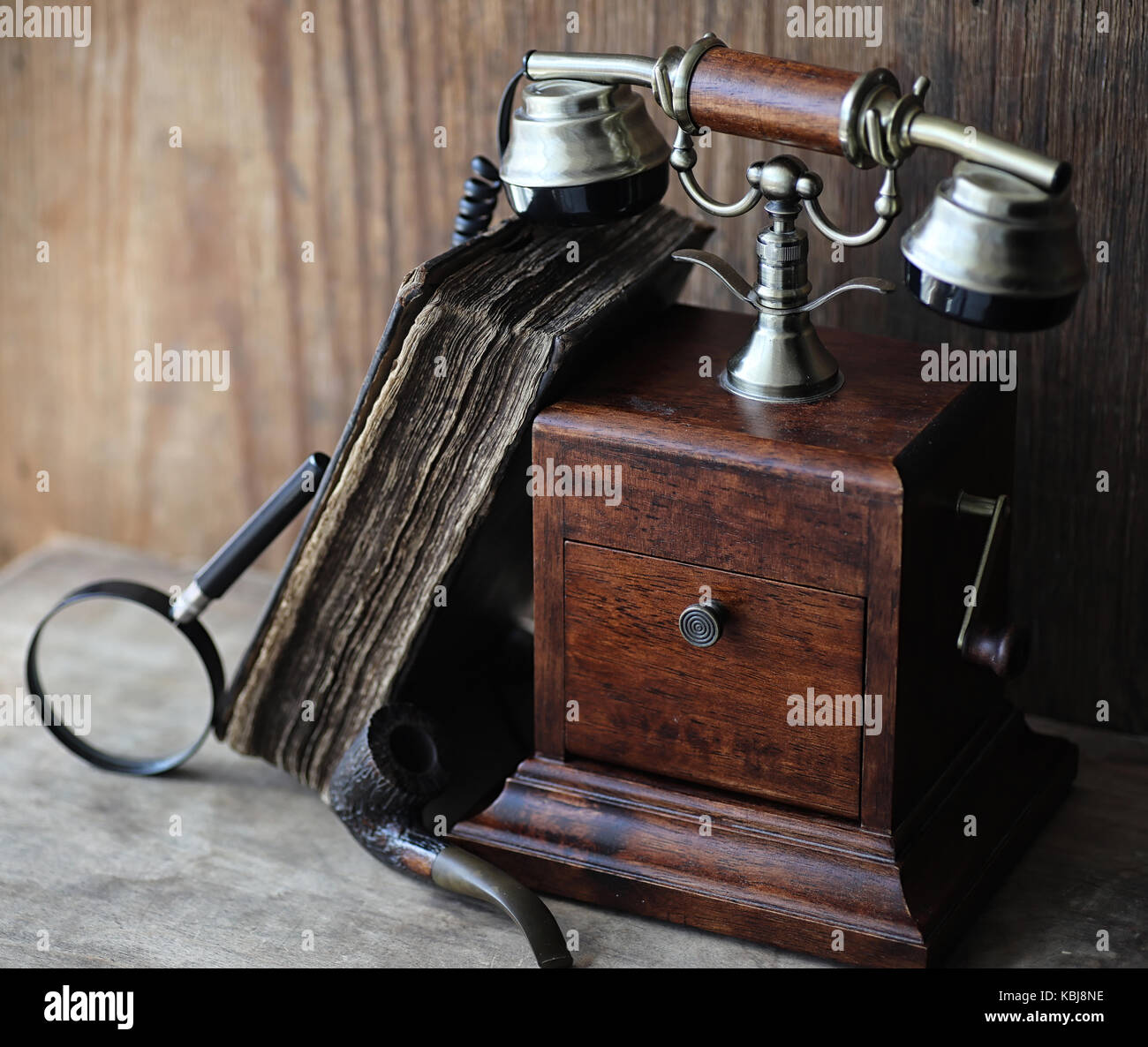Old telephone and retro book on a wood Stock Photo - Alamy