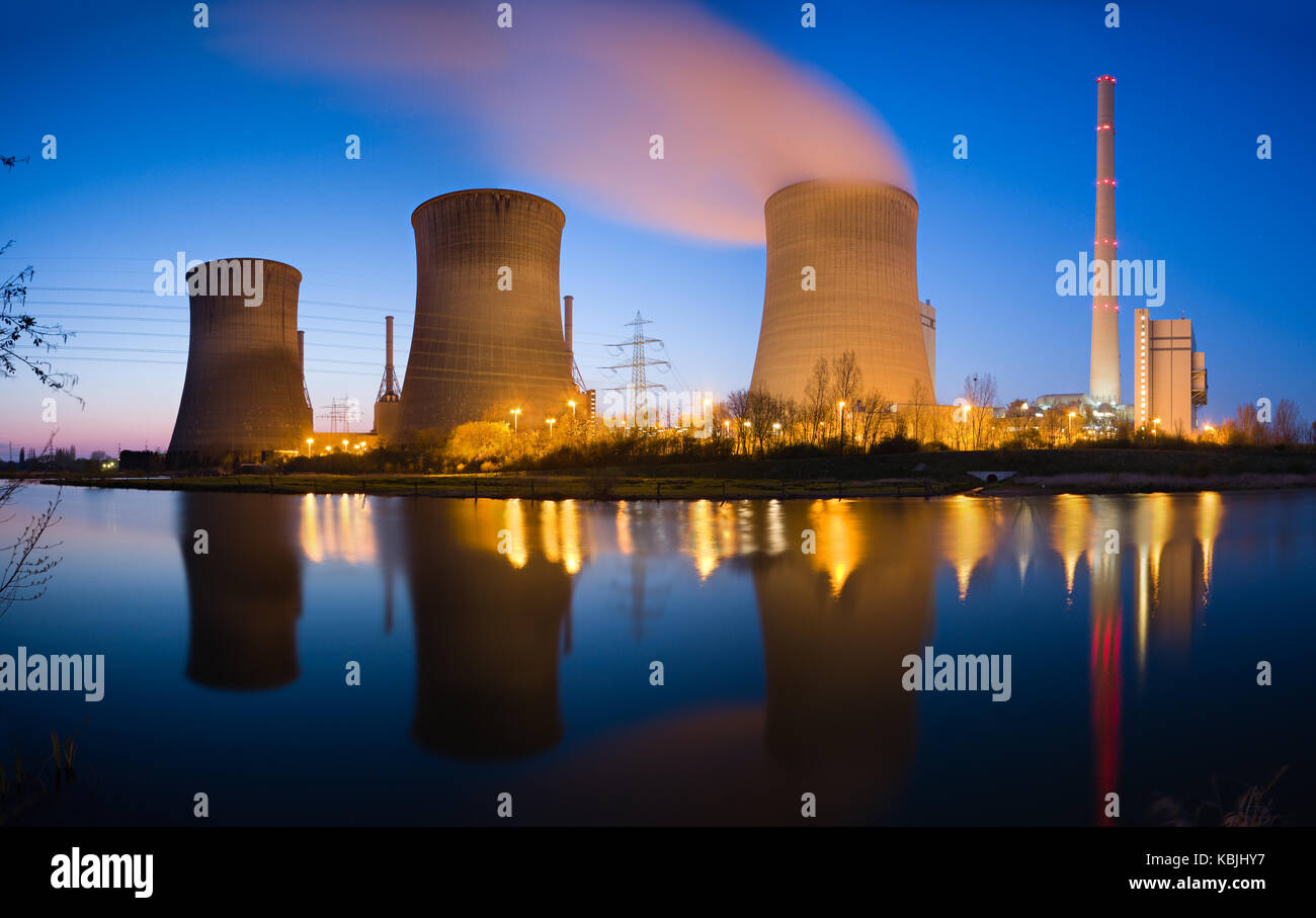 A coal-fired power station with reflection and beautiful night blue sky ...