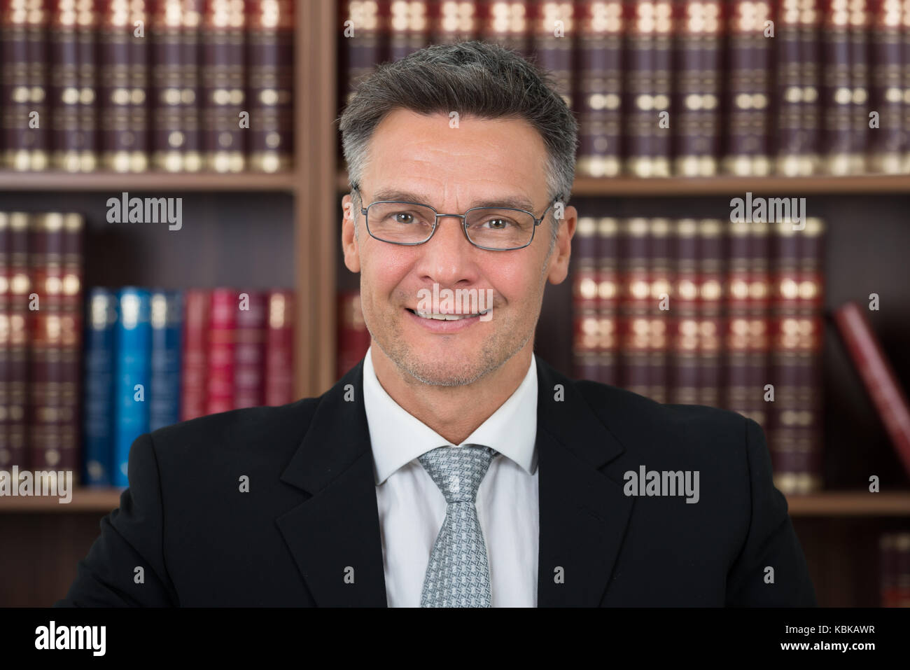 Portrait of confident mature male accountant against bookshelf in ...