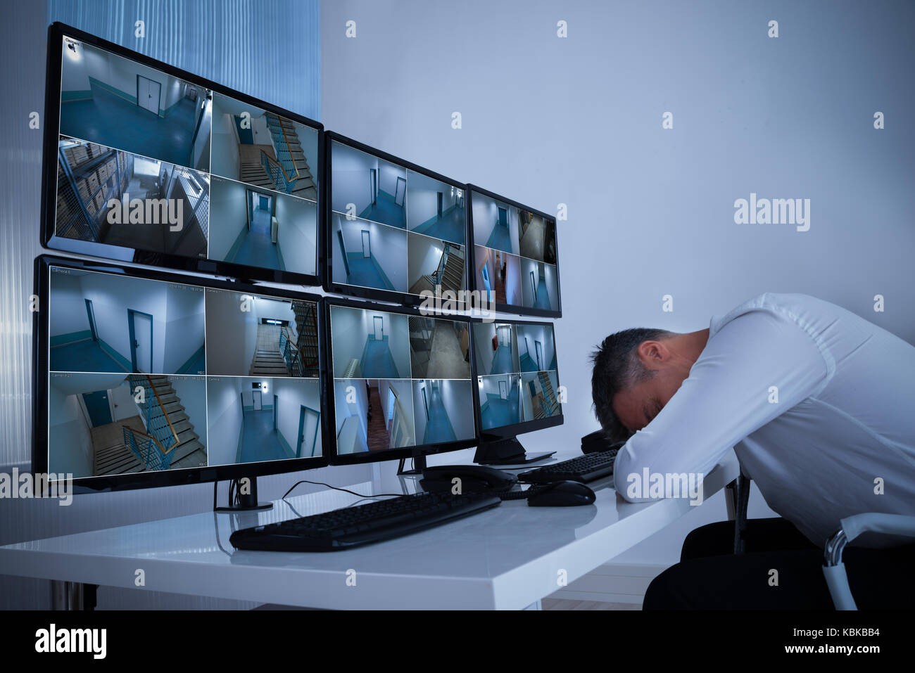 Side view of mature male operator sleeping while leaning on security ...