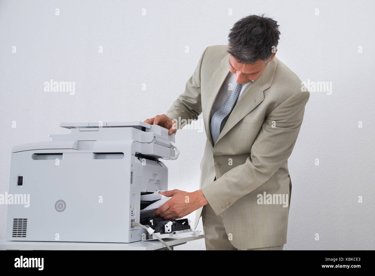 Mature Businessman Removing Paper Stuck In Printer At Office Stock Photo Alamy mature-businessman-removing-paper-stuck-in-printer-at-office-stock-photo-alamy