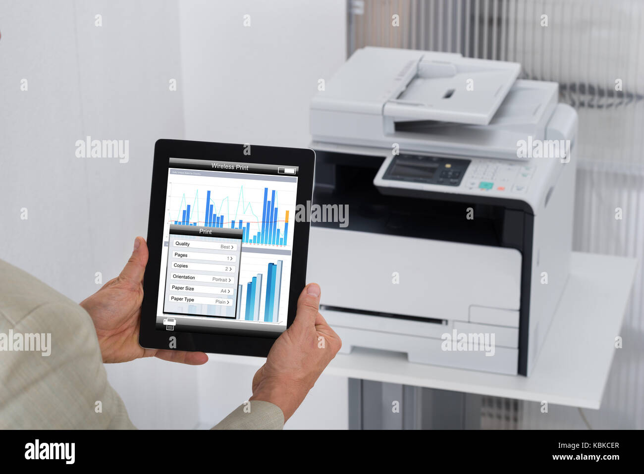 Cropped image of businessman giving print command on digital tablet in ...