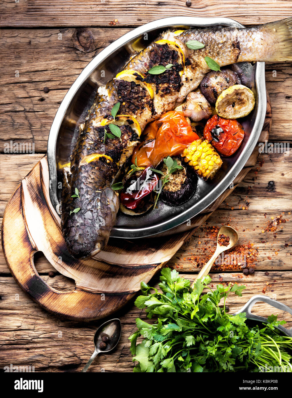 Cooked whole grilled fish with vegetable garnish Stock Photo - Alamy