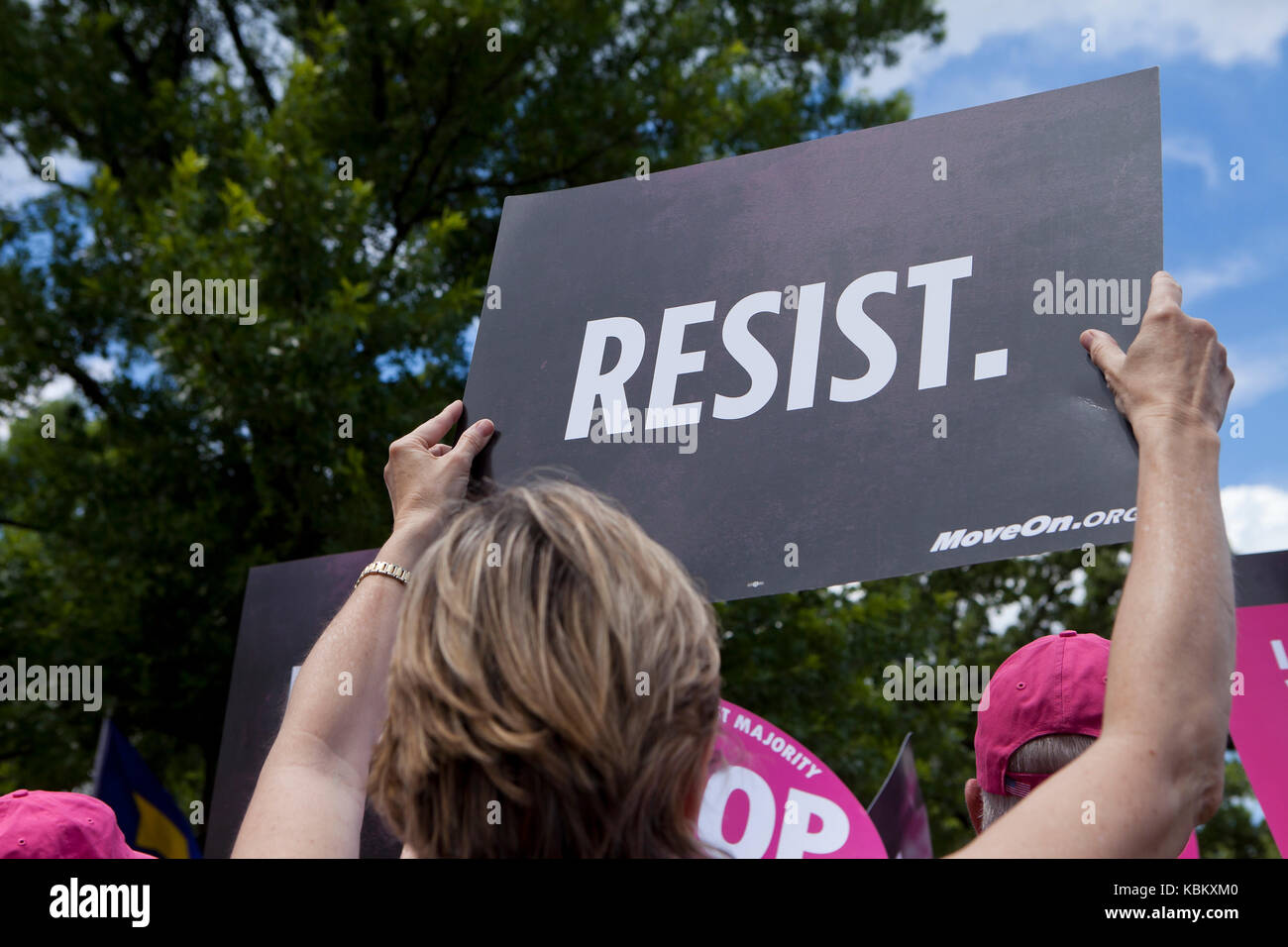 Woman holding RESIST sign at a progressive healthcare protest rally ...
