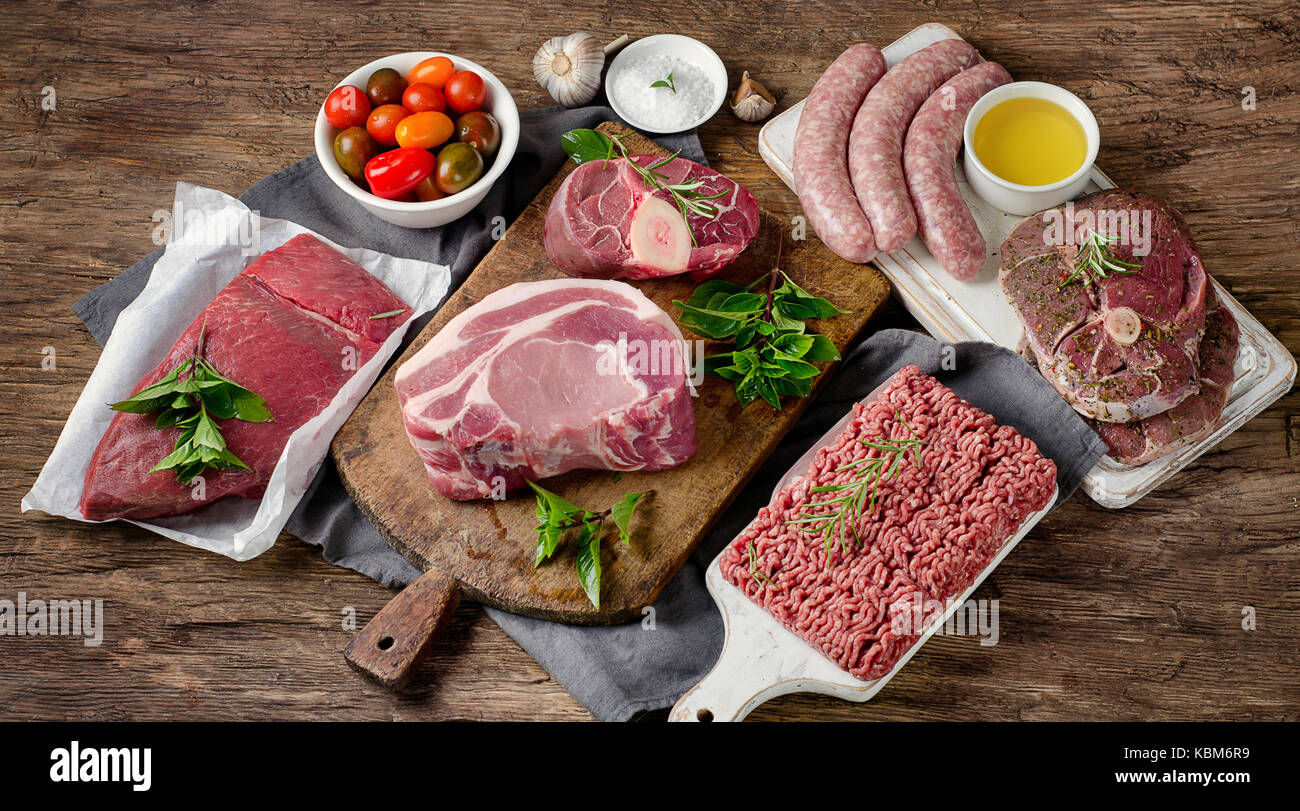 Different types of fresh raw meat on a rustic wooden background. Top ...
