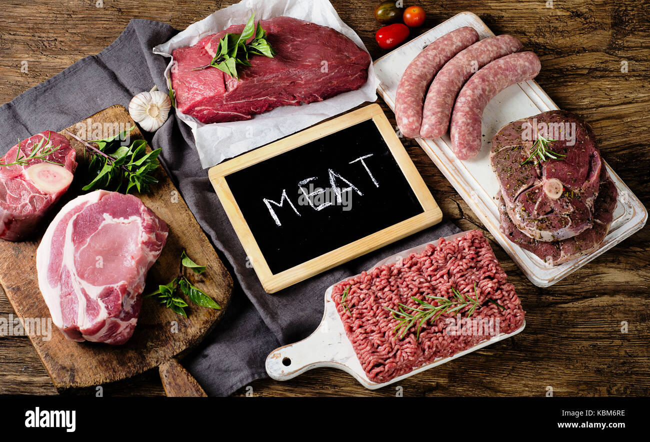 Different types of meat on a wooden background. Top view Stock Photo ...