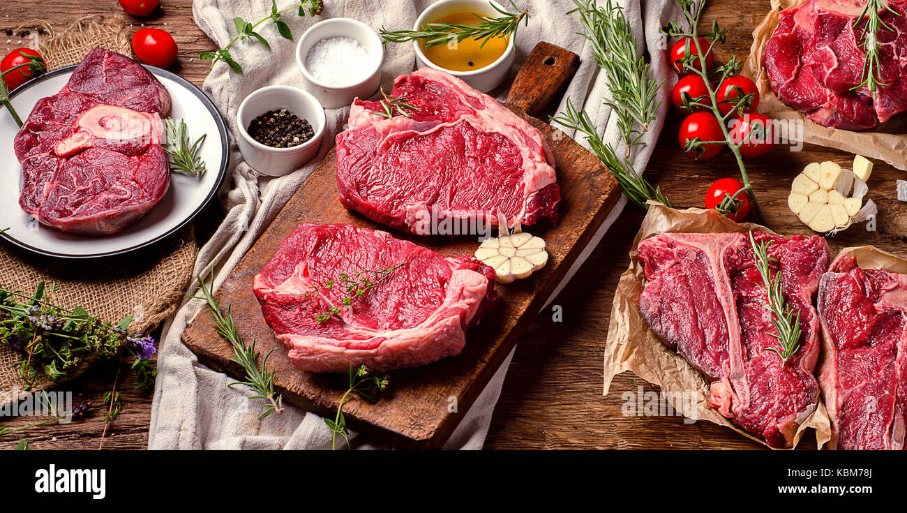 Raw beef meat on a dark wooden board. Top view Stock Photo - Alamy